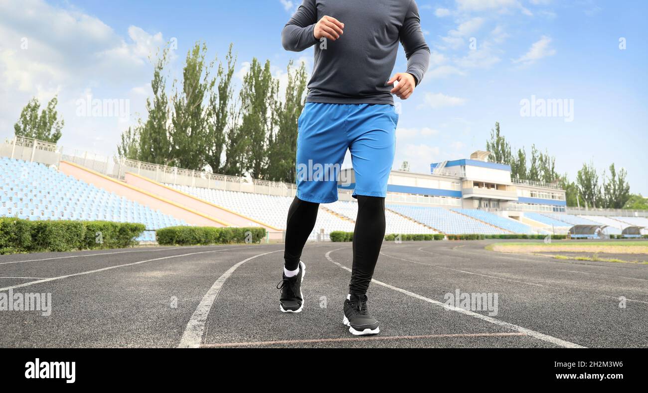 Muscular young man running at stadium Stock Photo - Alamy