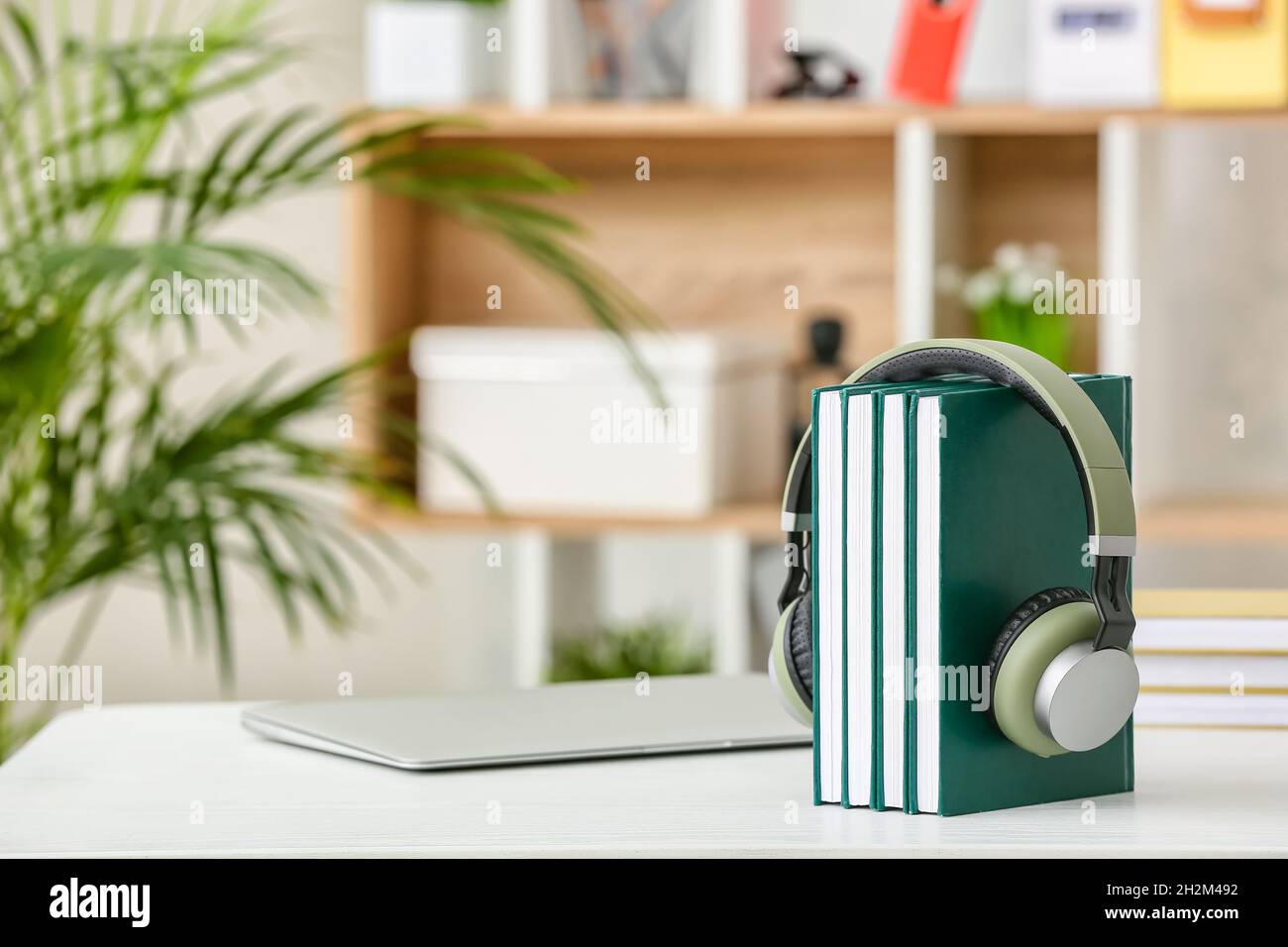 Modern headphones and books on table in room Stock Photo - Alamy
