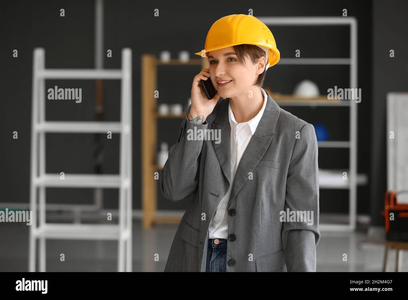 Female industrial engineer talking by mobile phone in office Stock ...