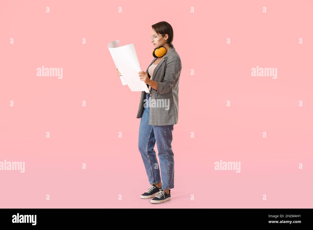 Female industrial engineer with house plan on pink background Stock ...