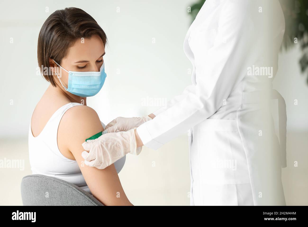 Doctor applying plaster onto woman's hand in clinic Stock Photo - Alamy