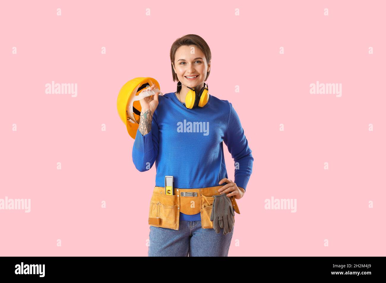 Female construction worker with hardhat on pink background Stock Photo ...