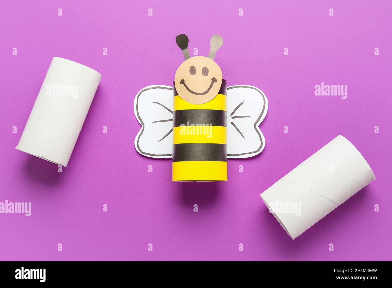 Bee made of cardboard and tubes for toilet paper on purple background ...