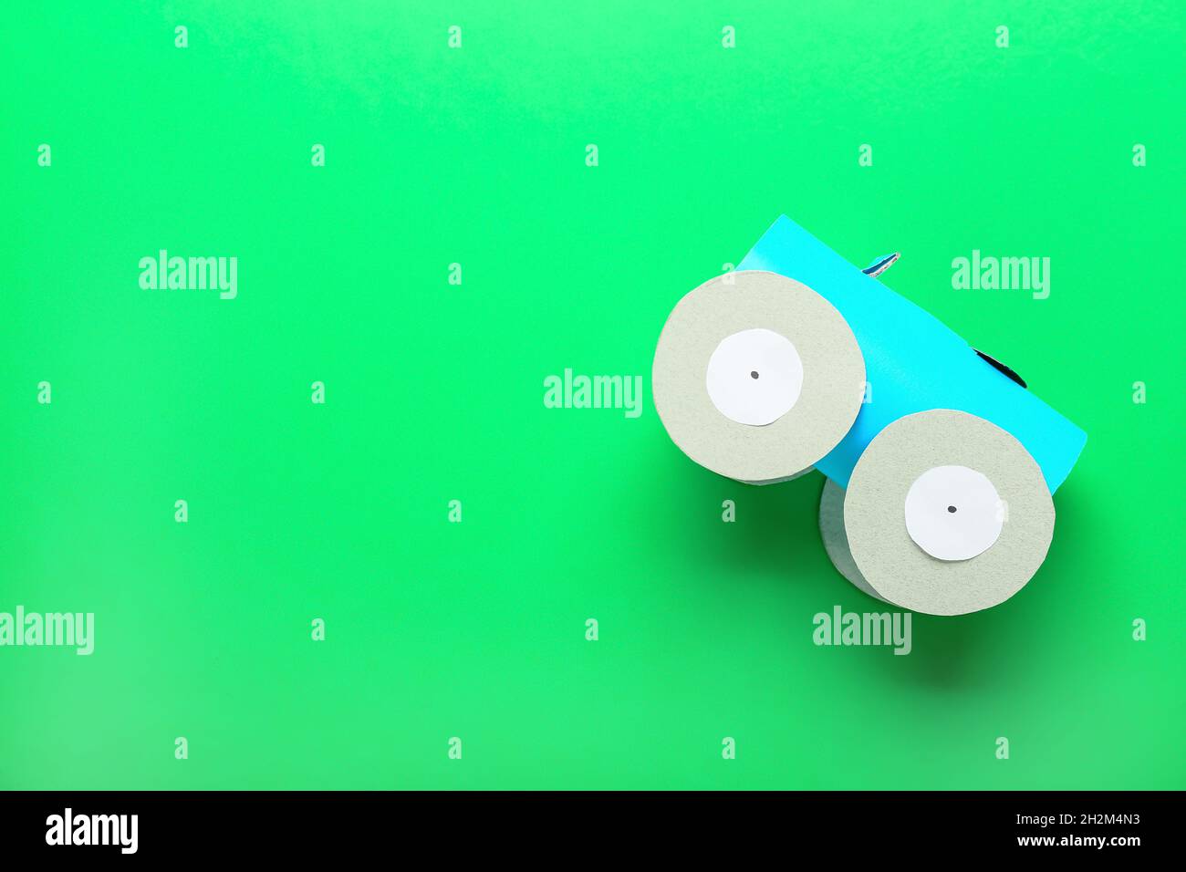 Car made of toilet paper tubes on green background Stock Photo - Alamy
