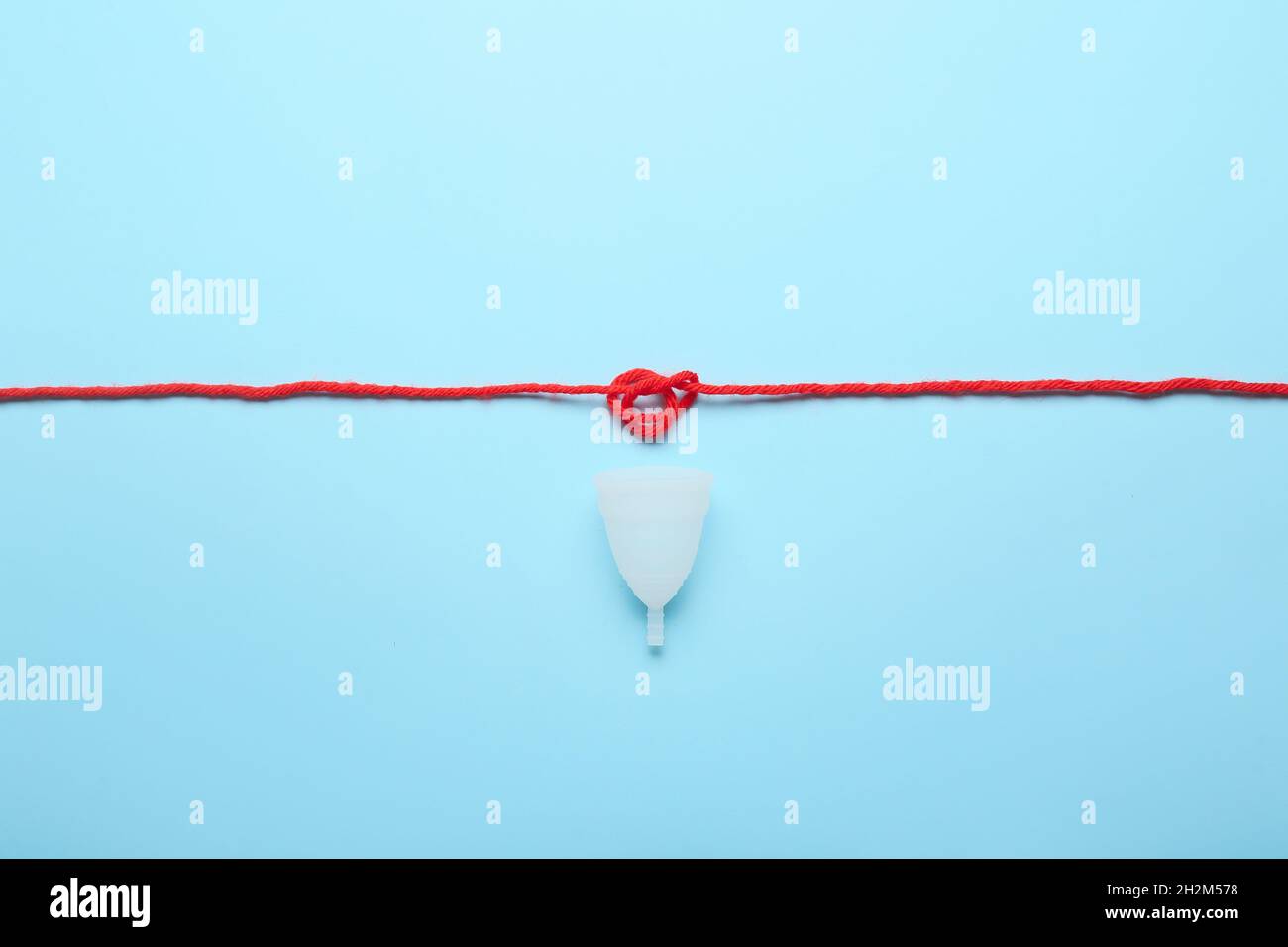 Menstrual cup and thread on color background Stock Photo - Alamy