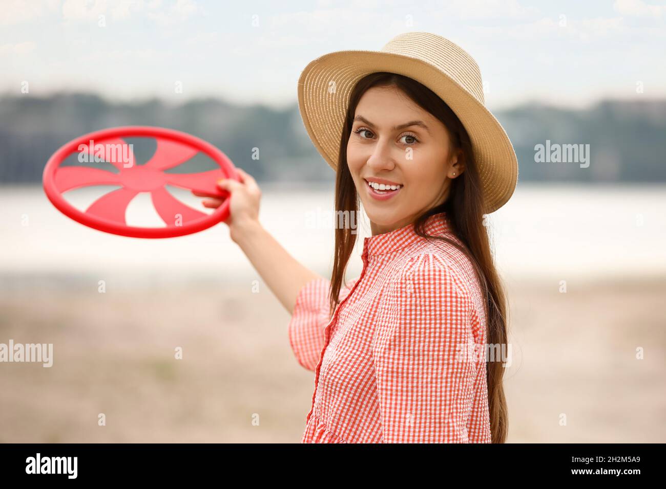 Beautiful young woman playing frisbee outdoors Stock Photo - Alamy
