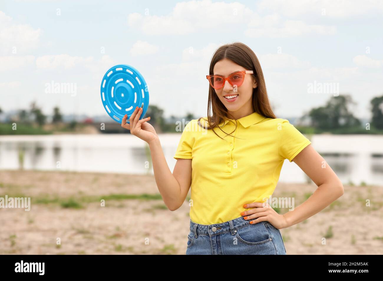 Beautiful young woman playing frisbee outdoors Stock Photo - Alamy