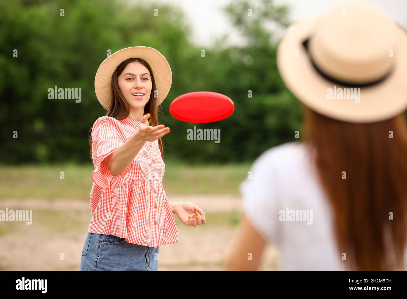 Beautiful young women playing frisbee outdoors Stock Photo - Alamy
