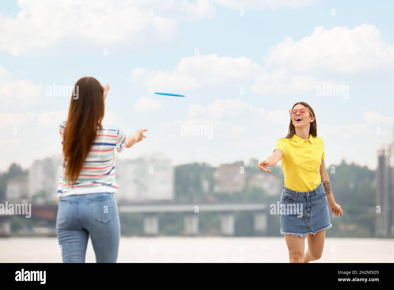 Beautiful young women playing frisbee outdoors Stock Photo - Alamy