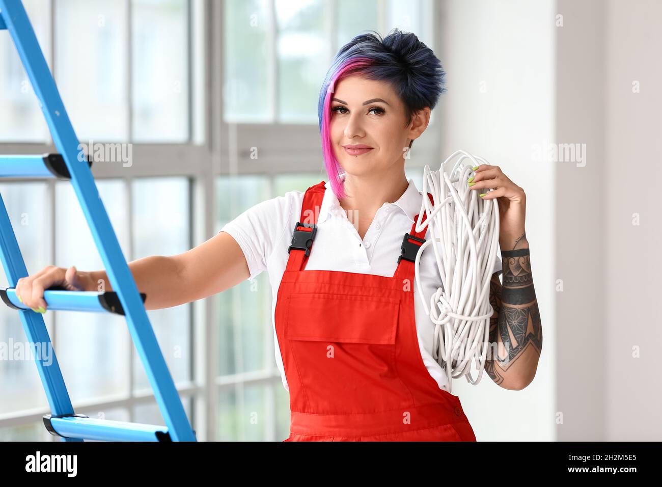 Female electrician with cables in room Stock Photo - Alamy