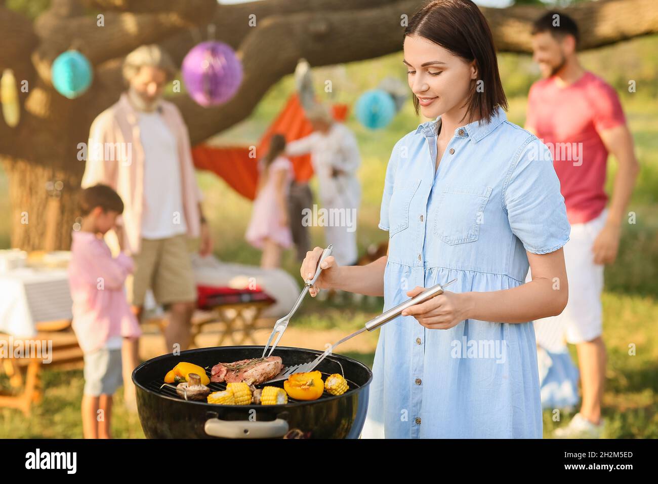 Happy woman cooking food at barbecue party on summer day Stock Photo ...