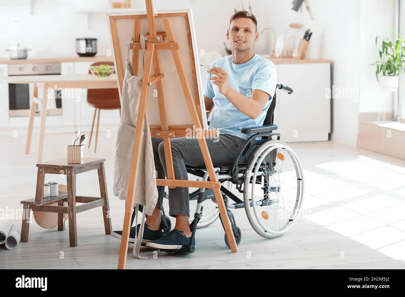 Young handicapped artist painting in workshop Stock Photo - Alamy
