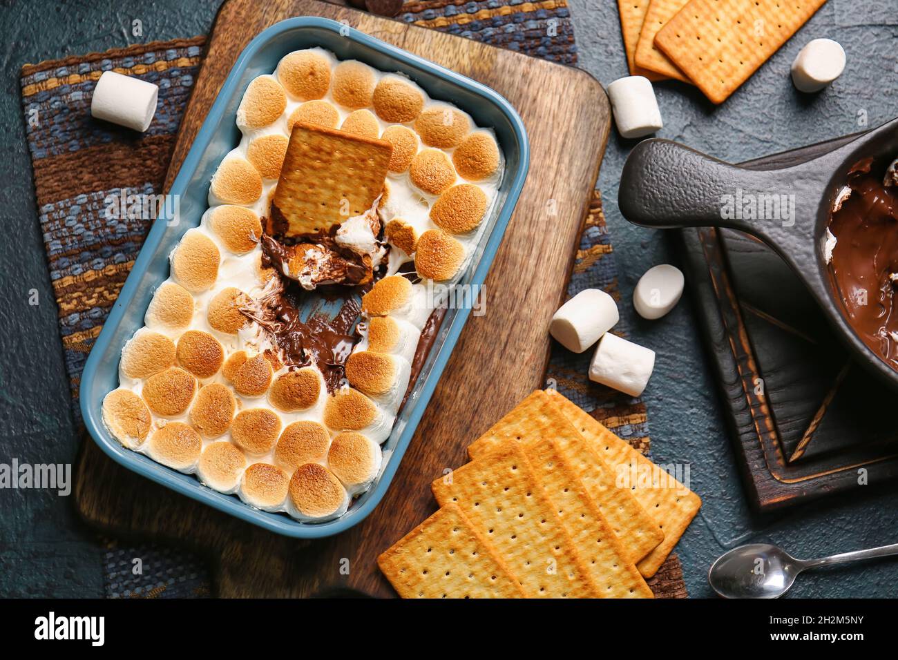 Composition with tasty S'mores dip and crackers on dark background ...