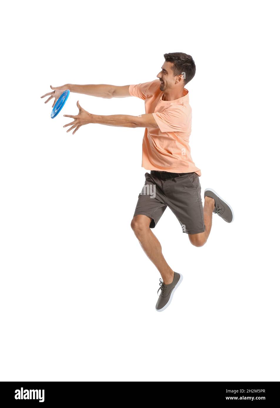Young man catching frisbee on white background Stock Photo - Alamy