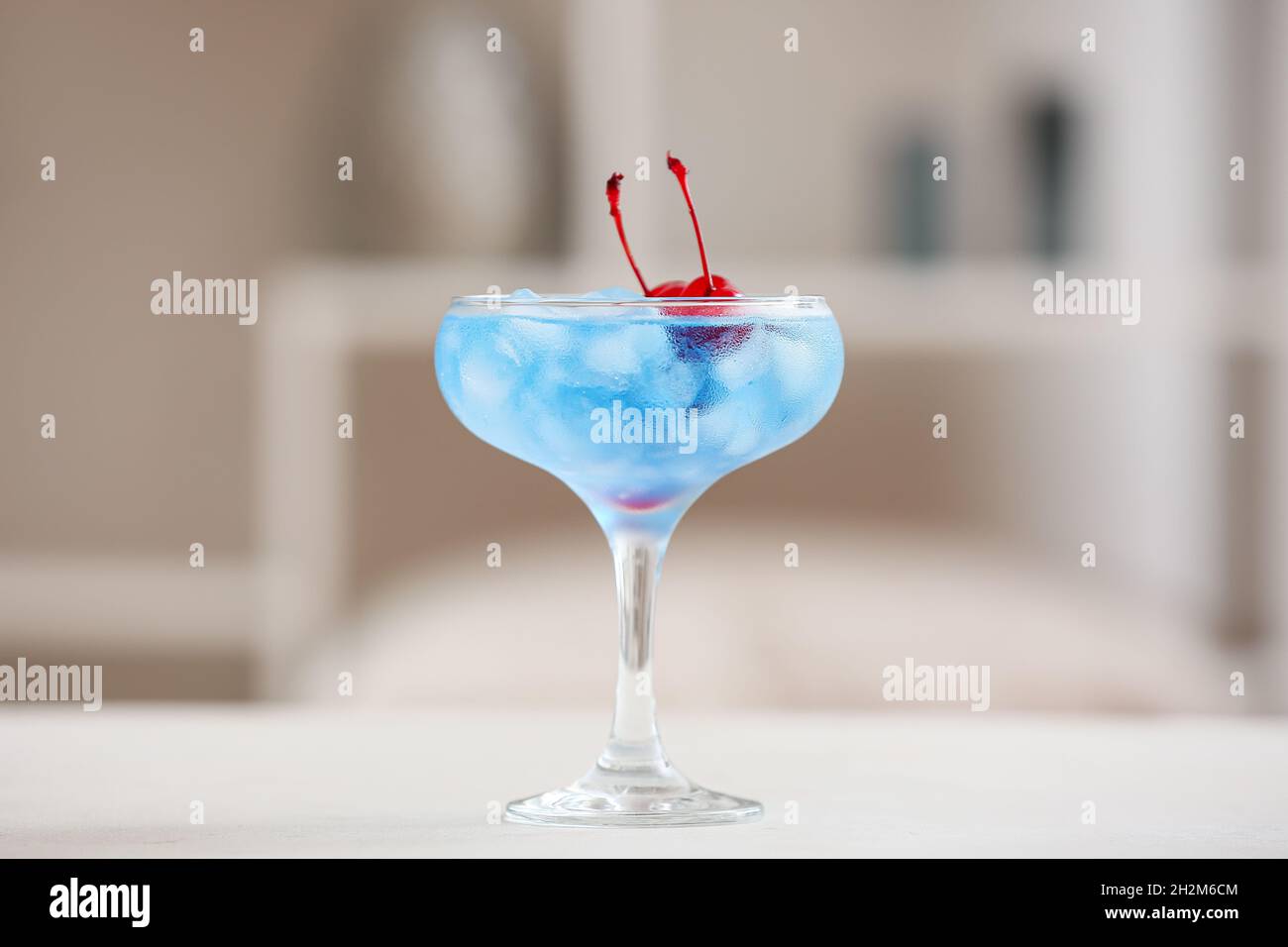 Glass of Blue Lagoon cocktail on table in room Stock Photo - Alamy