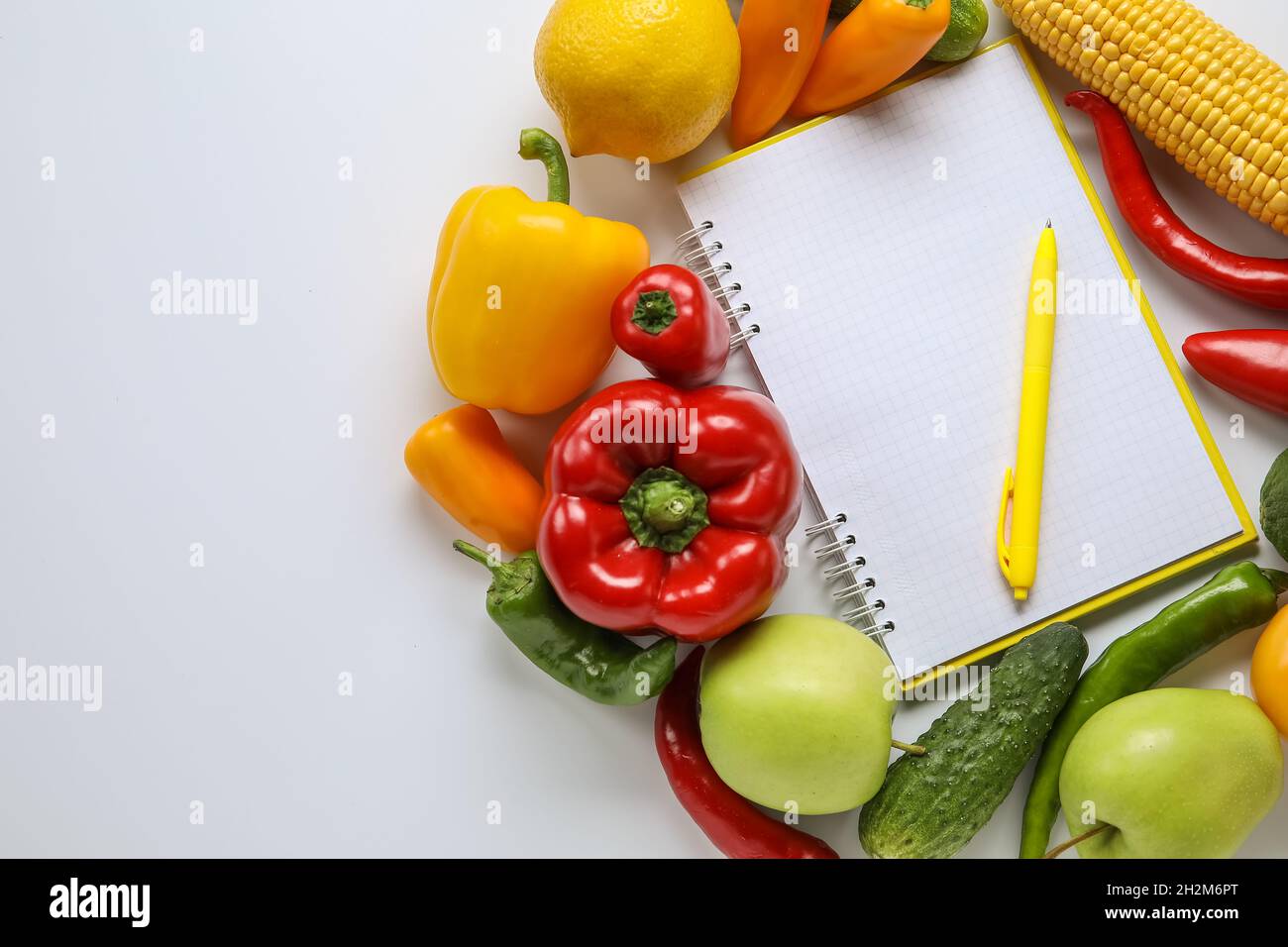 Blank notebook, pen, vegetables and fruits on white background. Vegan ...