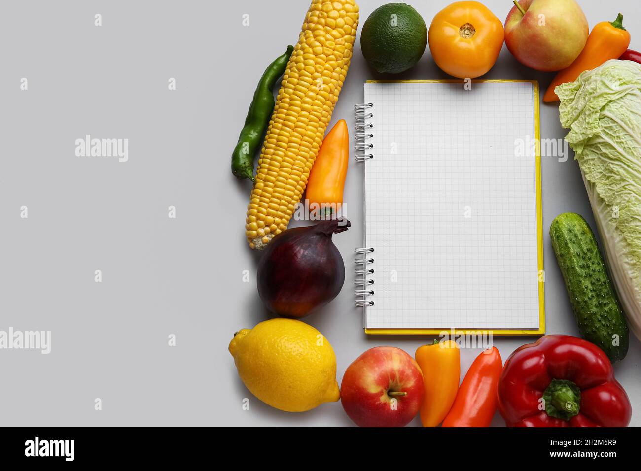 Blank notebook, fruits and vegetables on grey background. Vegan Day ...
