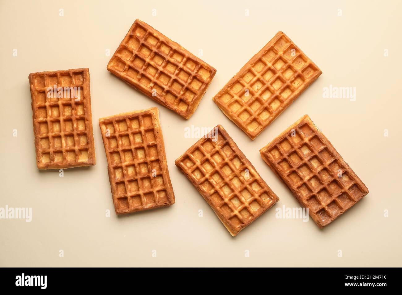 Tasty golden Belgian waffles on beige background Stock Photo - Alamy