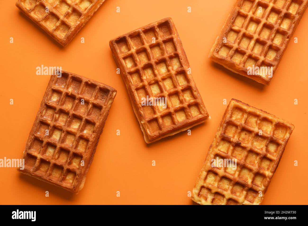 Delicious Belgian waffles on orange background Stock Photo - Alamy