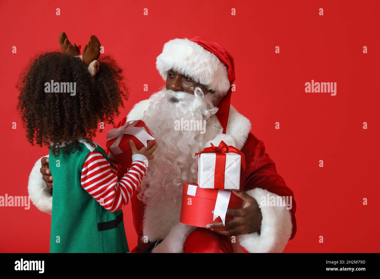 Cute little elf with Santa Claus and gifts on red background Stock ...