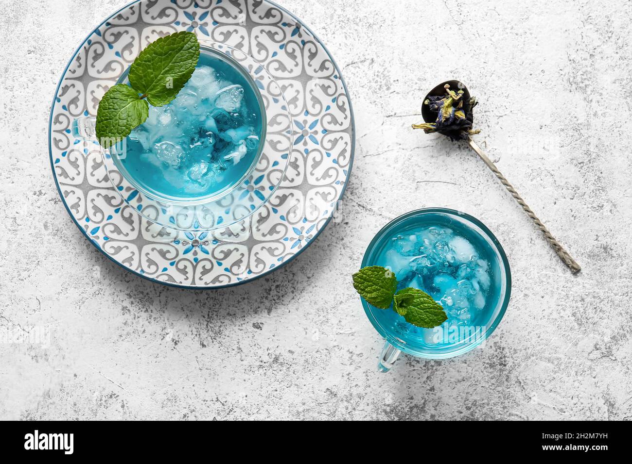 Glass cups of iced blue tea on light background Stock Photo - Alamy