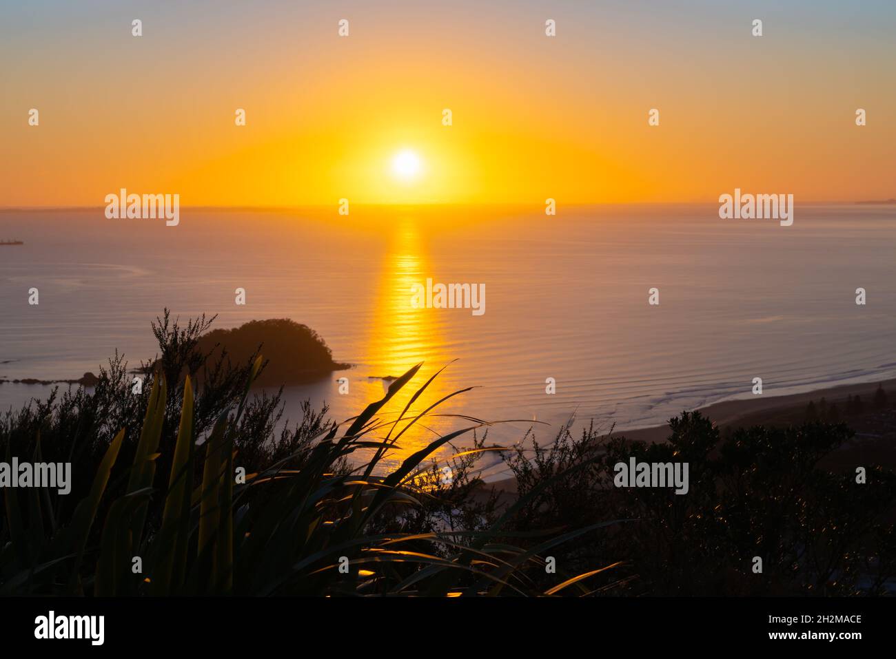 Golden glow of rising sun on distant horizon with long leading ...