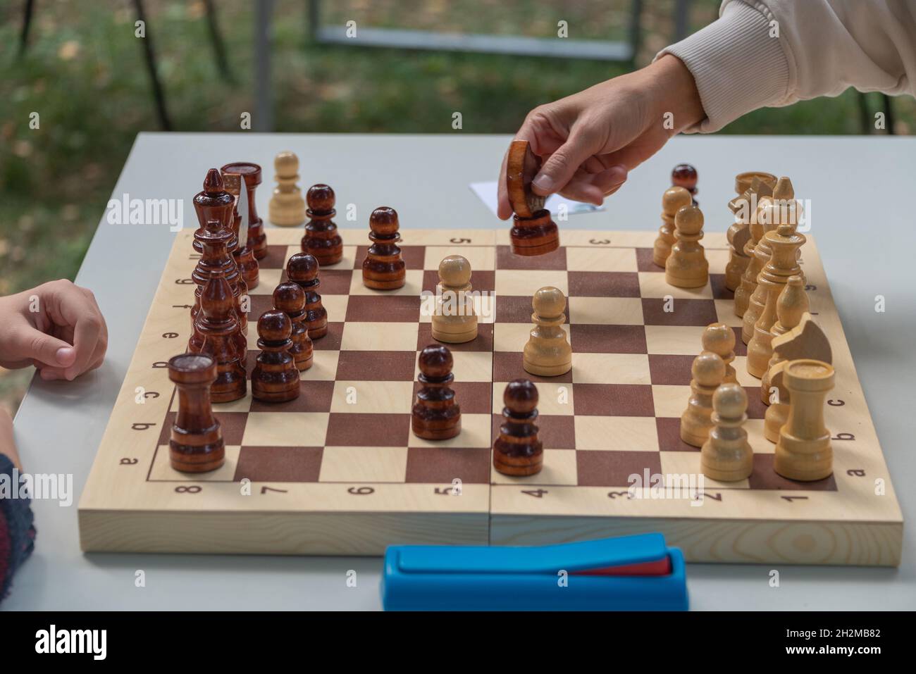 women's hands on the chessboard at the table on the street at ...