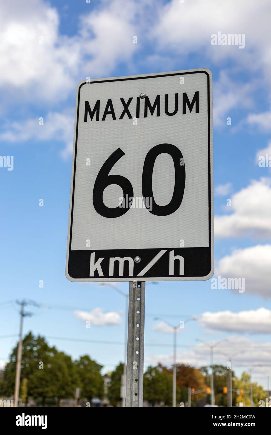 Speed limit road sign in the street against blue sky with clouds, 60 km ...