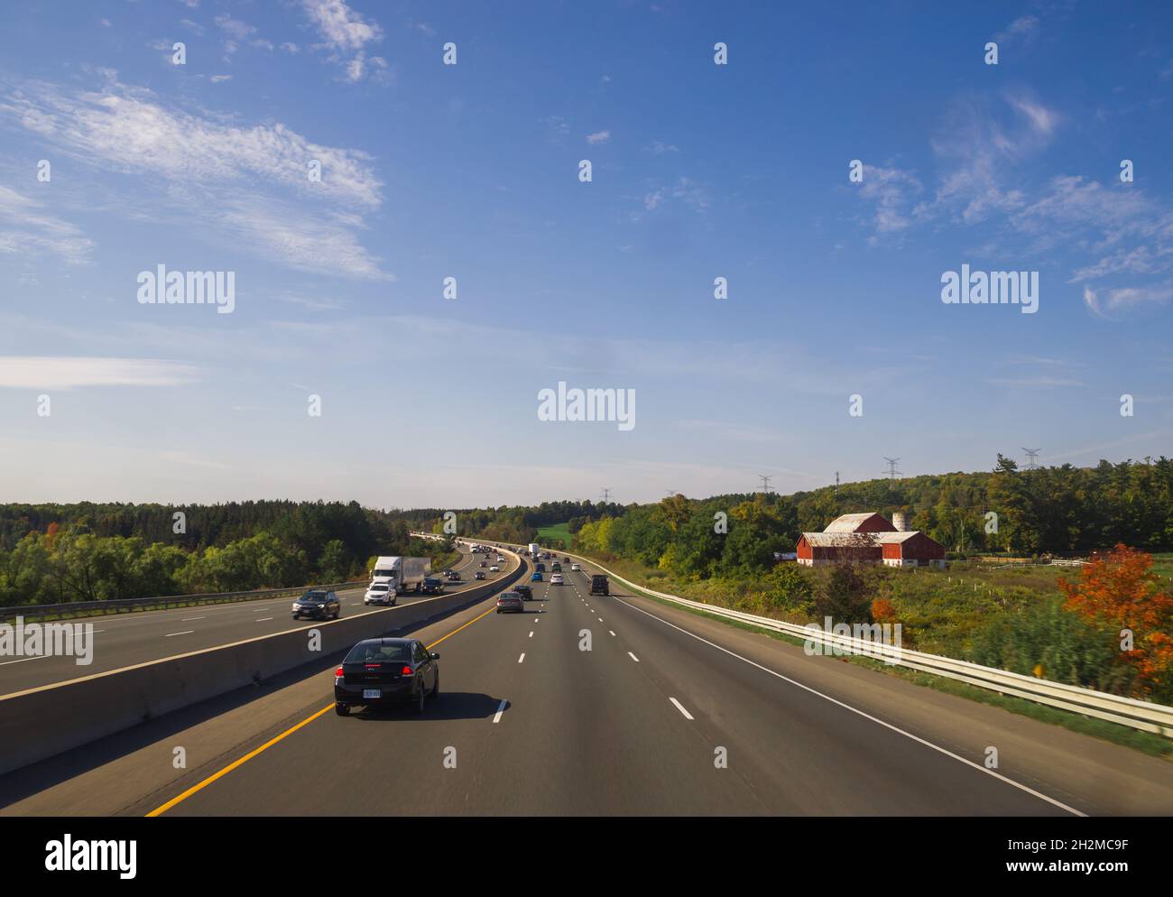 Highway through the countryside. Traffic on the road - cars and trucks ...
