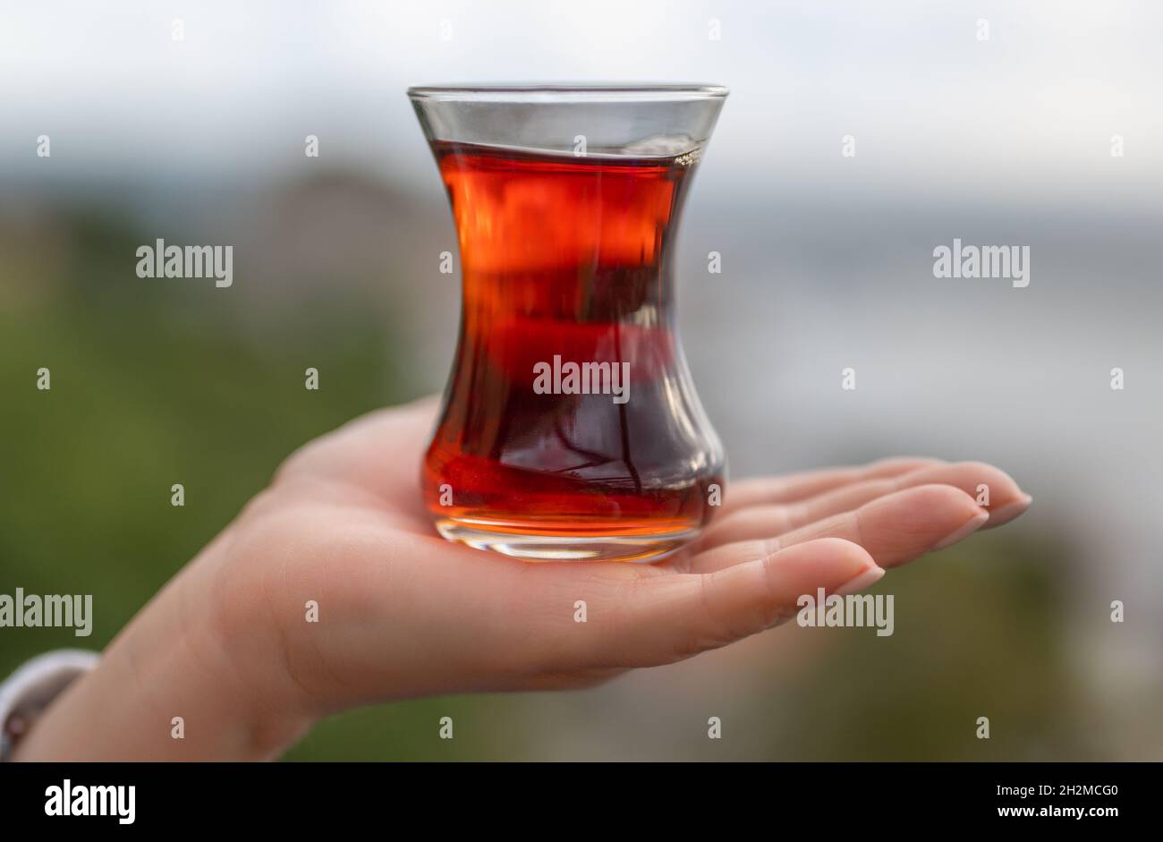 Tea cup armudas on woman hand palm, traditional Turkish tea against ...