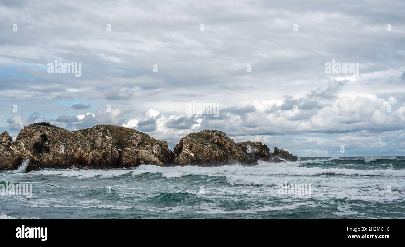 Ocean water splash on rock beach with beautiful sunset sky and clouds ...