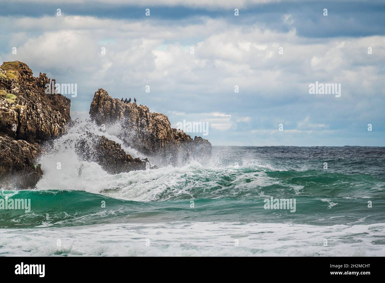 Ocean water splash on rock beach with beautiful sky and clouds. Sea ...