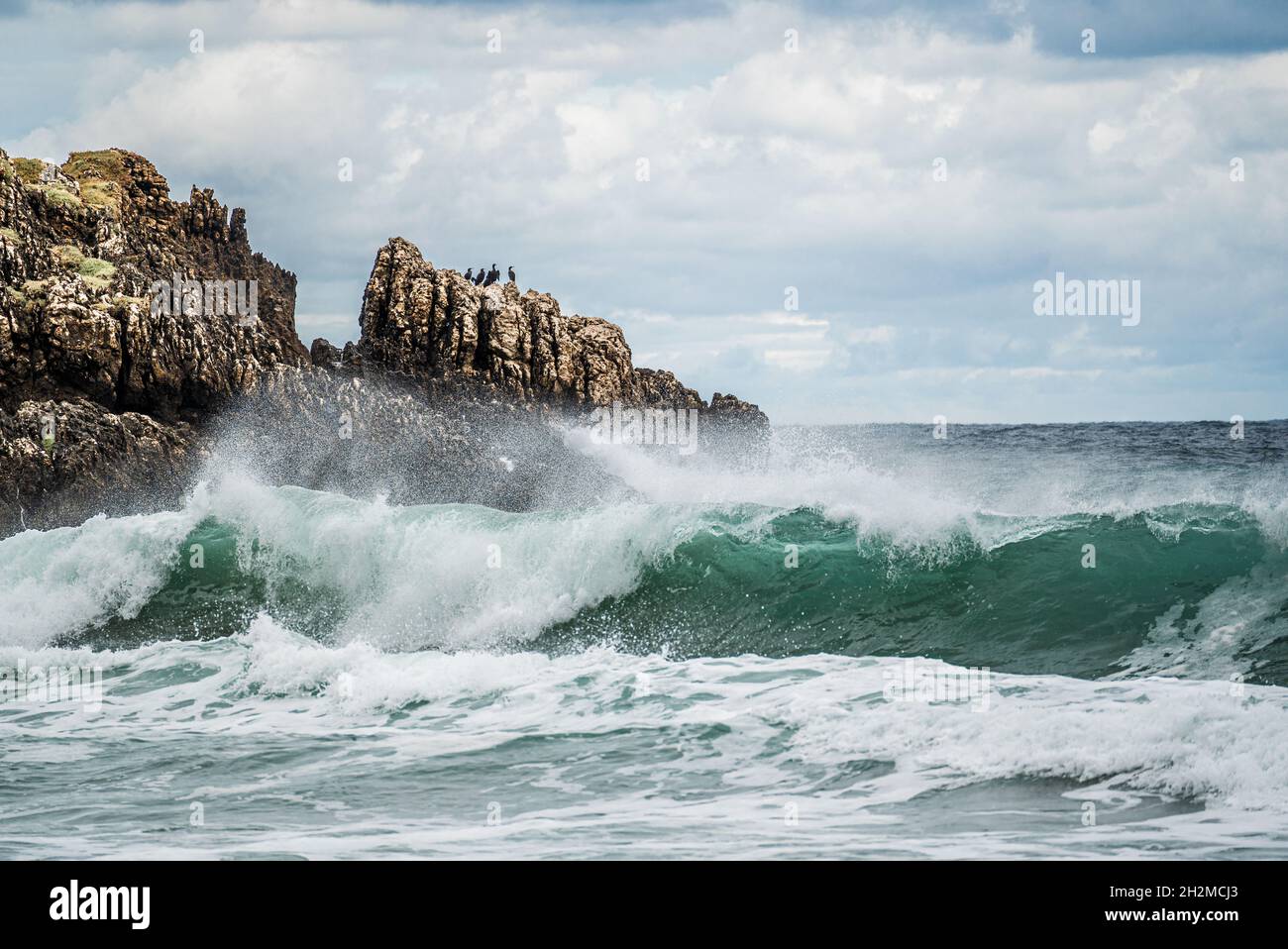 Ocean water splash on rock beach with beautiful sky and clouds. Sea ...
