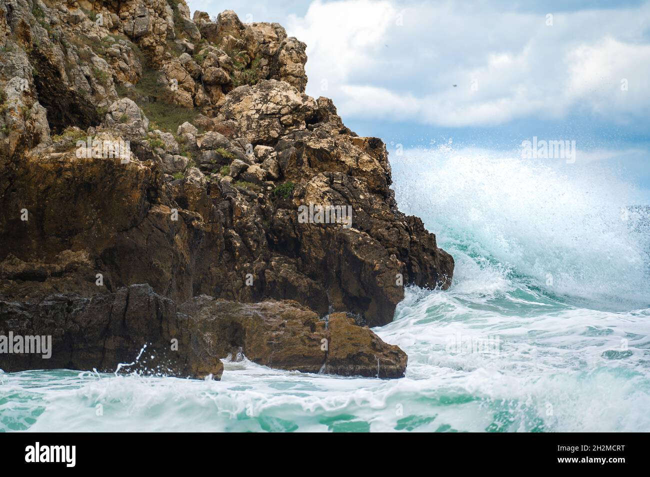 Ocean water splash on rock beach with beautiful sky and clouds. Sea ...