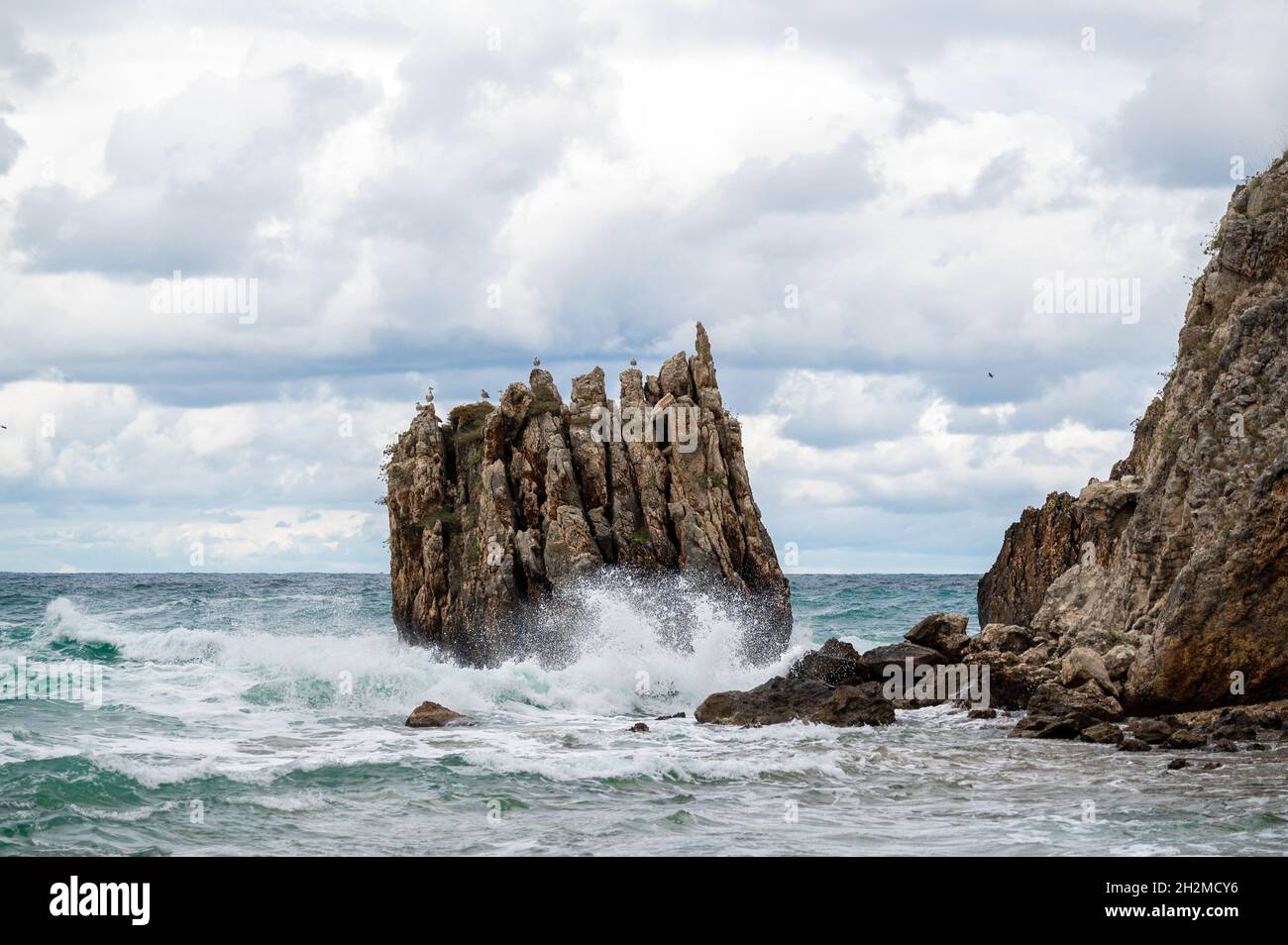 Ocean water splash on rock beach with beautiful sky and clouds. Sea ...