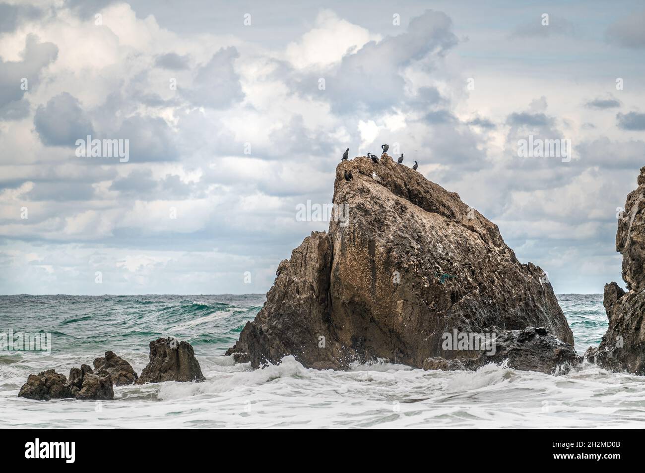 Ocean water splash on rock beach with beautiful sky and clouds. Sea ...