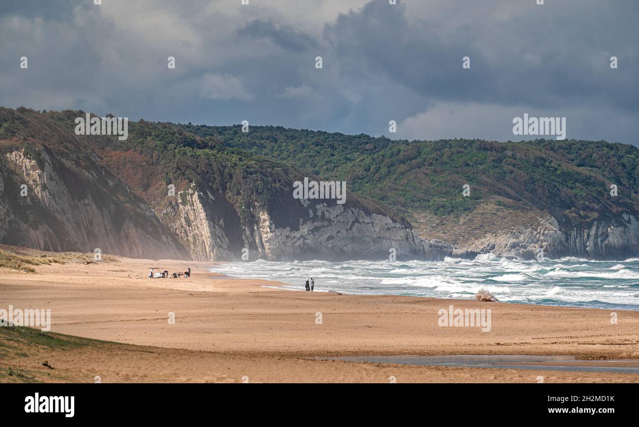 Beautiful sandy ocean beach with large rocks on shore and in the water ...