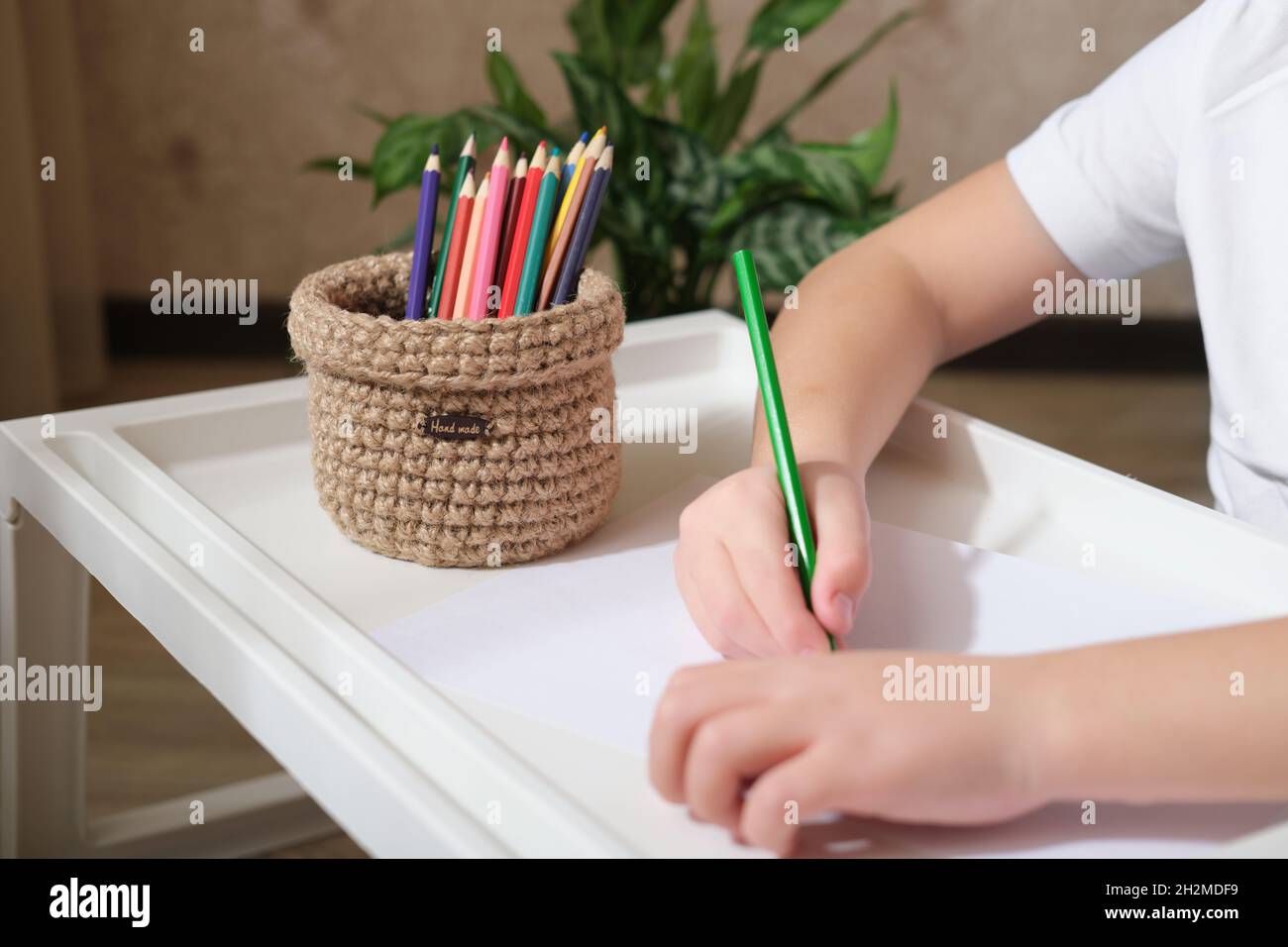 kid's hands drawing with color pencils and woven wicker basket for ...