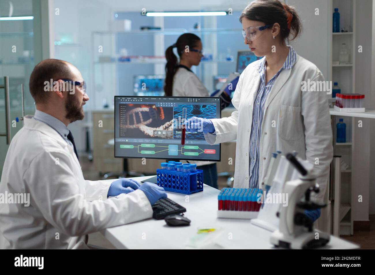 Medical team examining blood sample discussing virus expertise during ...