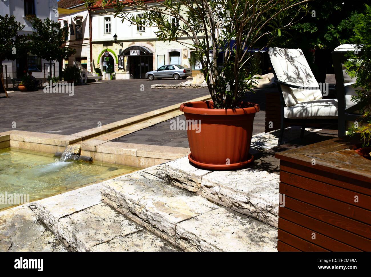 old european town square with stone stair, cobblestone pavement, potted ...