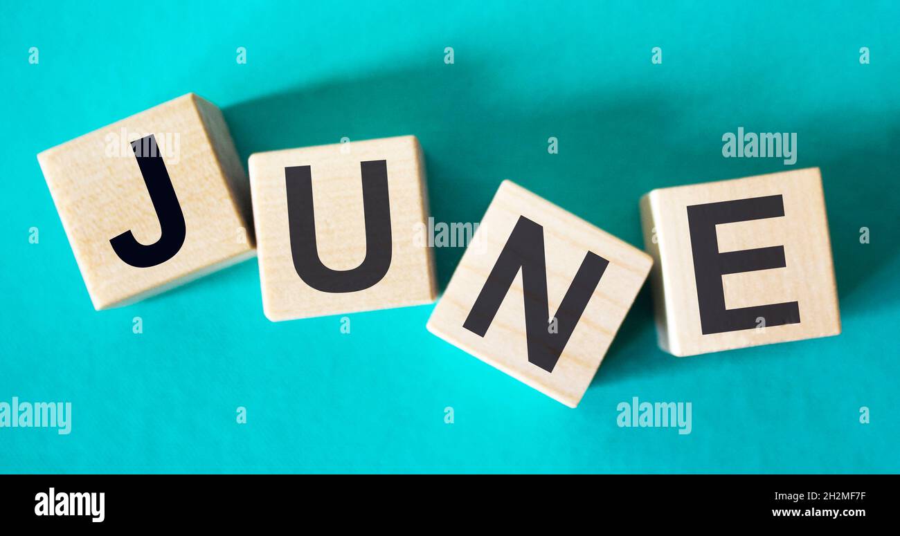 Text June on wooden blocks and a turquoise background Stock Photo - Alamy