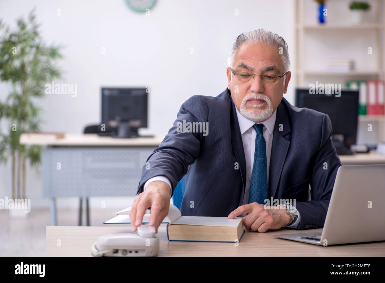 Old businessman employee speaking on the phone in the office Stock ...