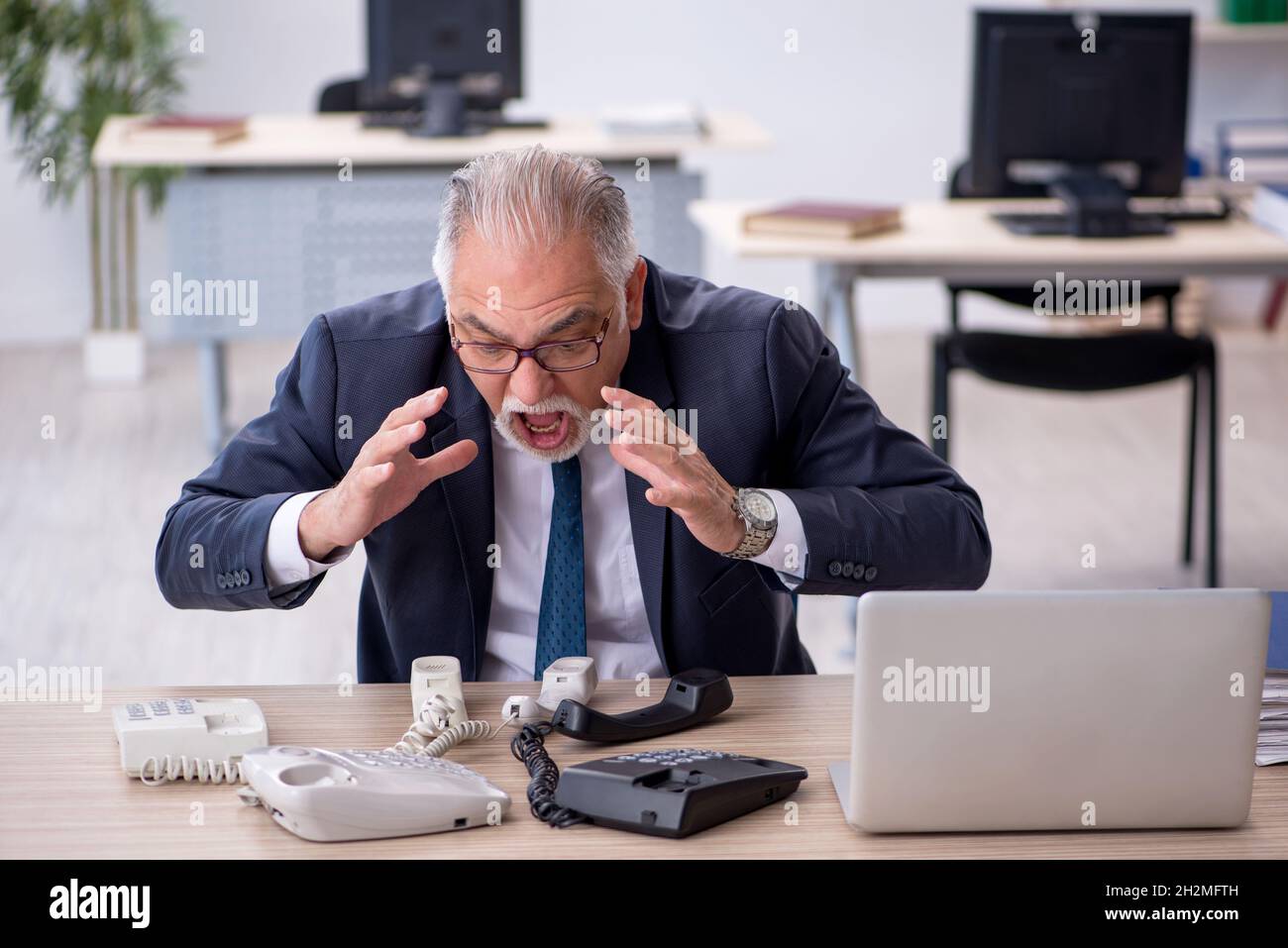 Old businessman employee speaking on the phone in the office Stock ...