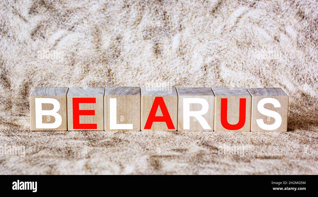 Red and white letters in the word Belarus on wooden cubes and sand ...