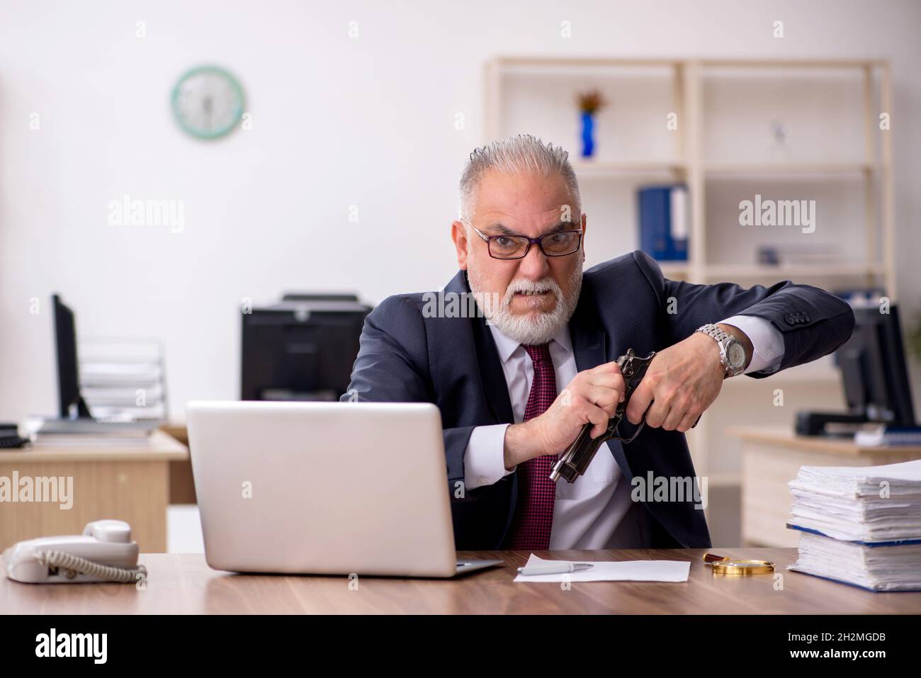 Old male employee holding gun at workplace Stock Photo - Alamy