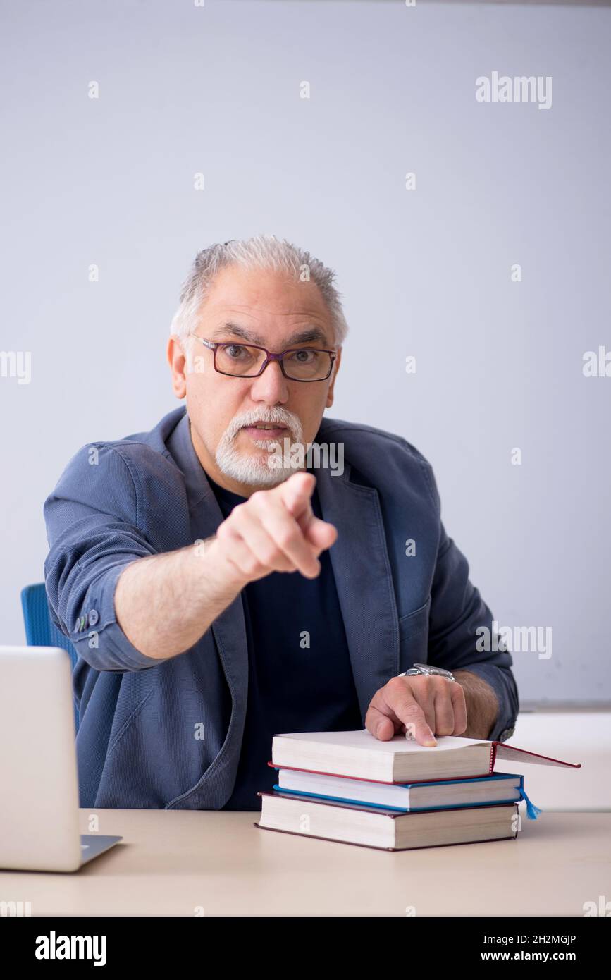 Old teacher in the classroom Stock Photo - Alamy