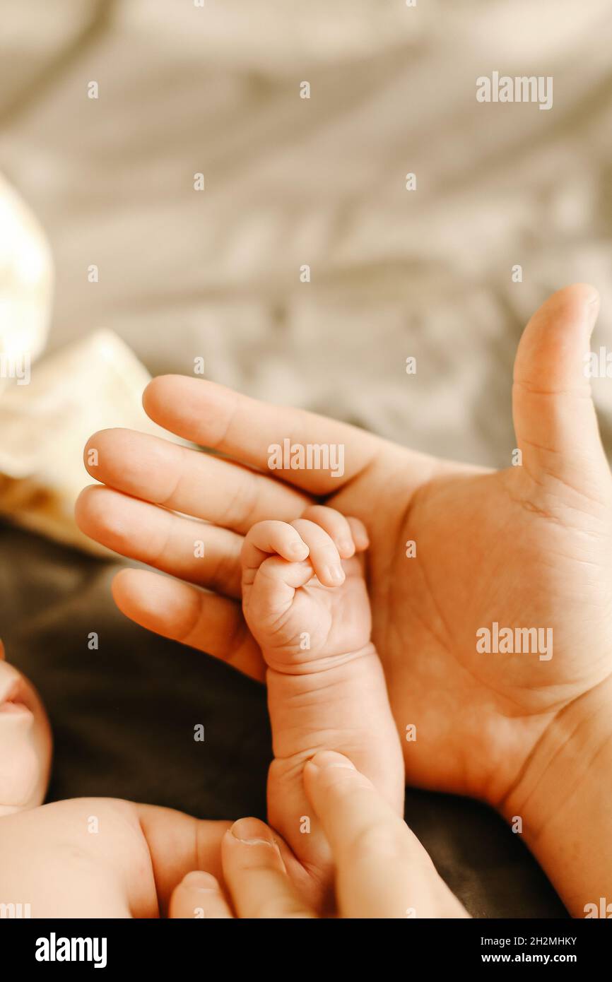 Close up photo of mother hand holding baby arm Stock Photo - Alamy