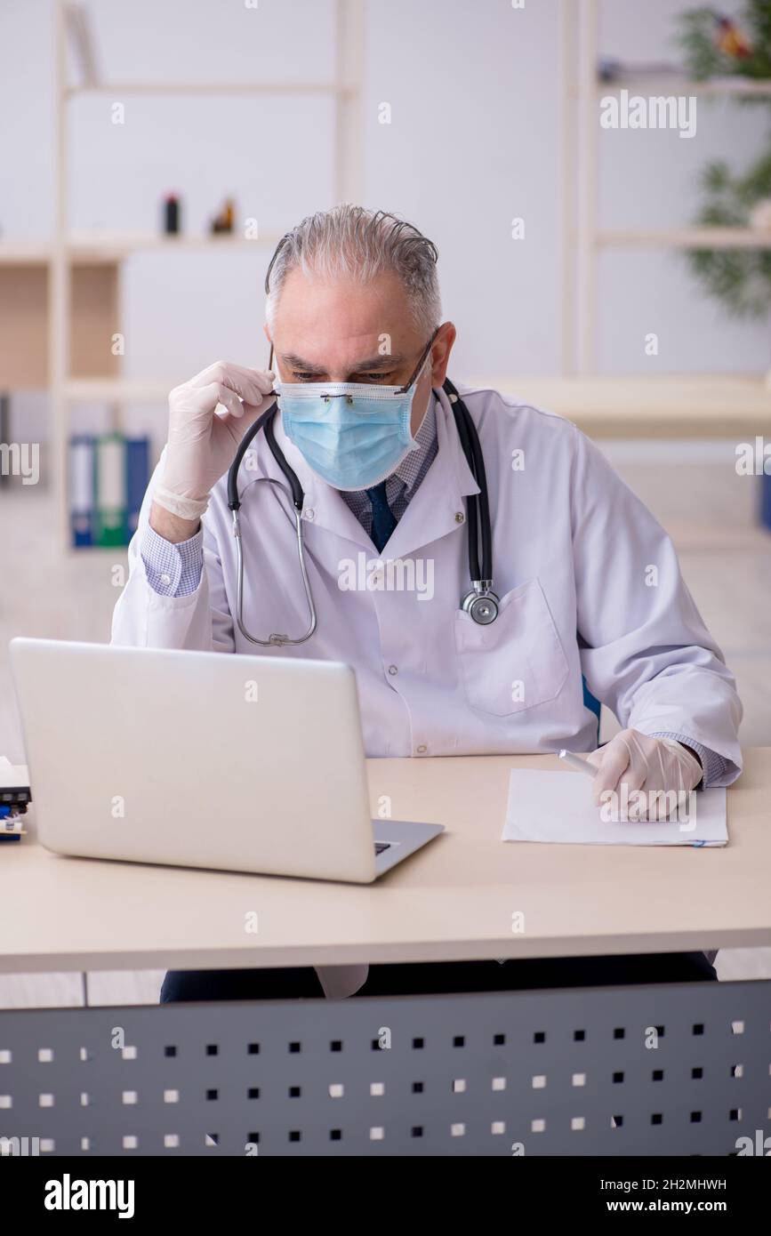 Old doctor working in the clinic Stock Photo - Alamy