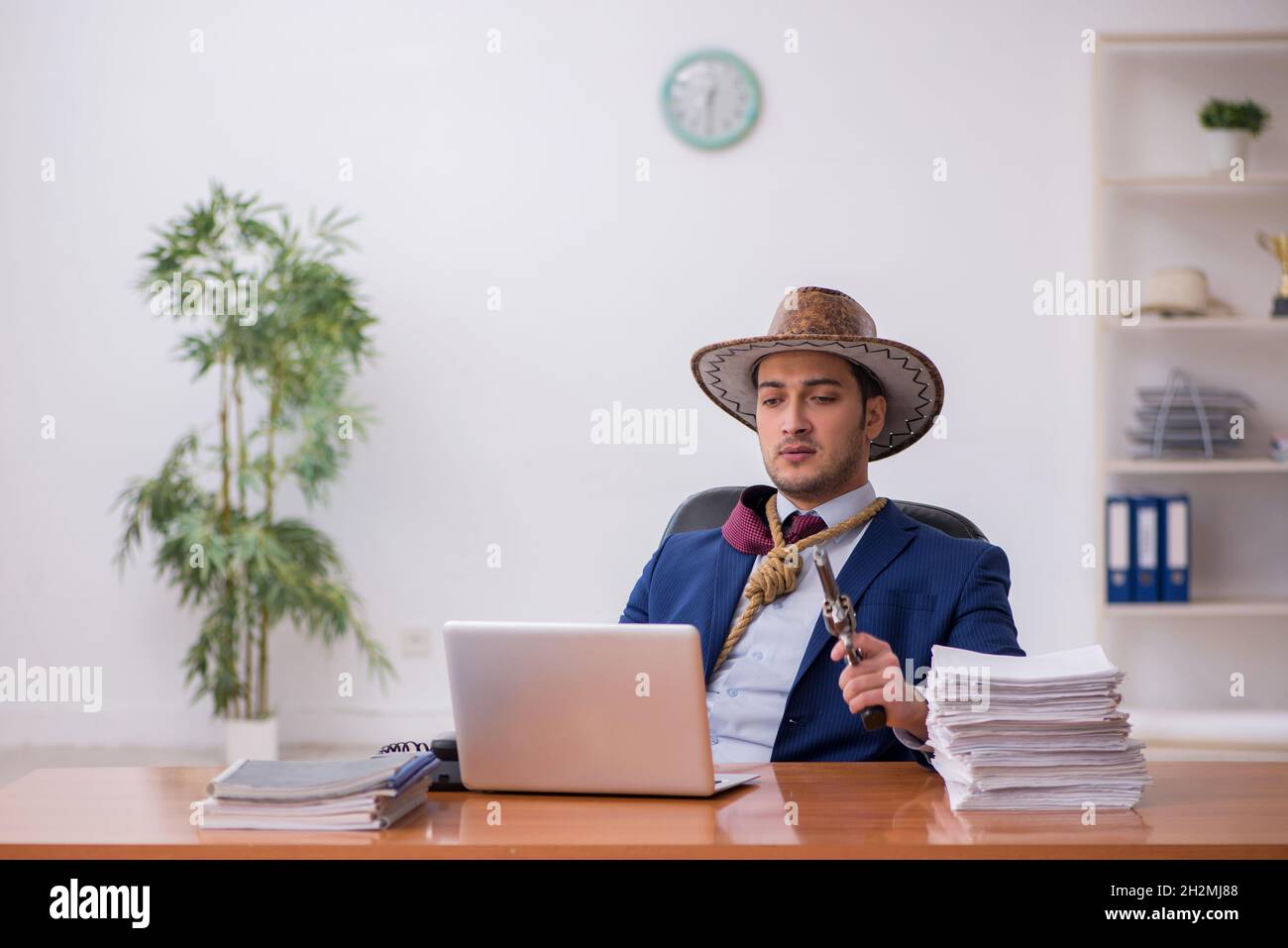 Young cowboy employee working at workplace Stock Photo - Alamy