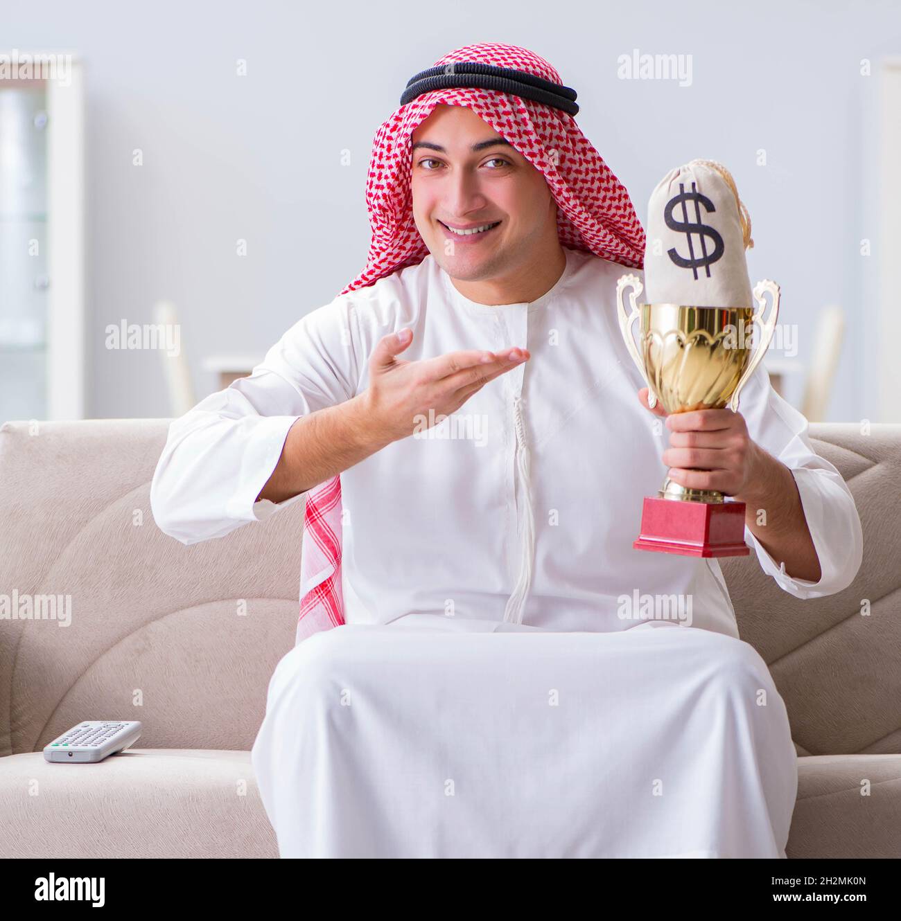 The arab man with prize and money on sofa Stock Photo - Alamy